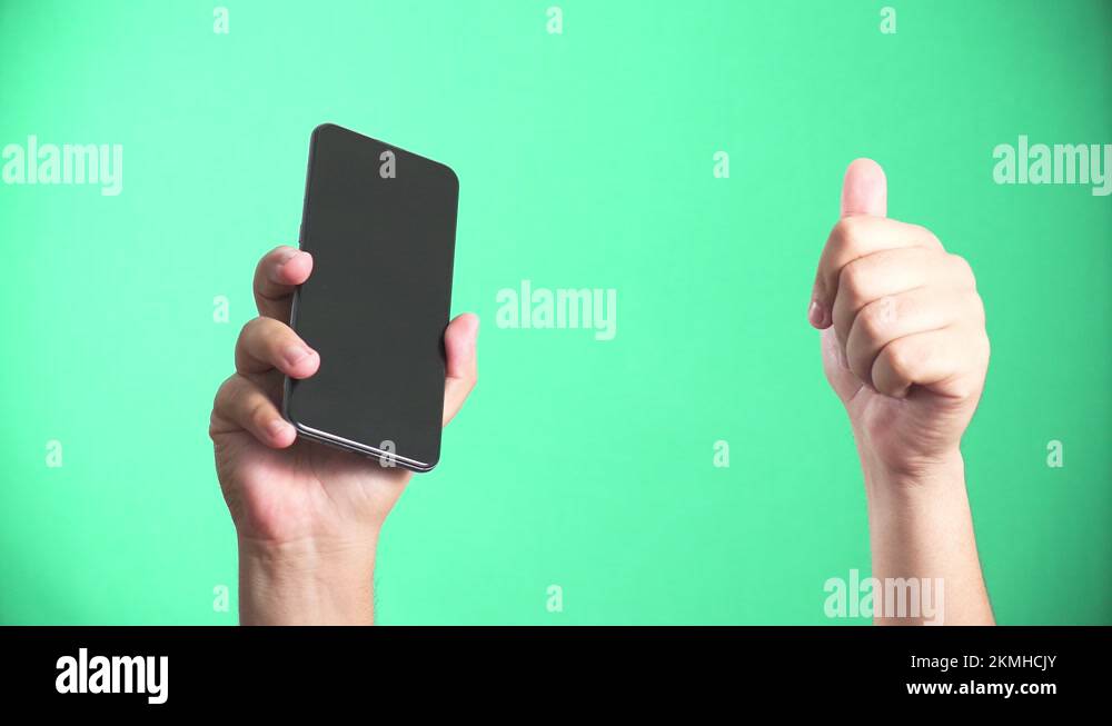 A contented person holding a cell phone with his hand. 4k Green screen ...