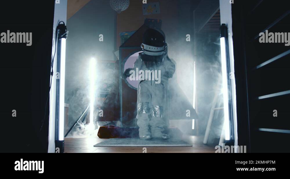 Cinematic zoom in on happy spaceman child dancing in astronaut suit in ...