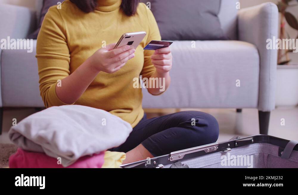 Woman booking flight online with her cell phone and credit card for ...