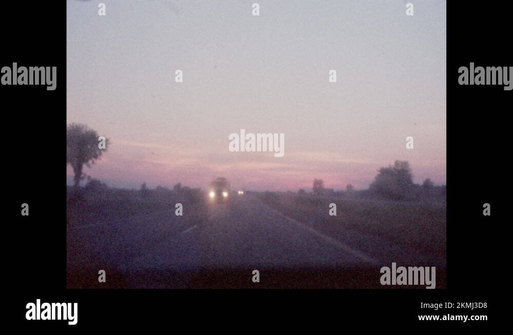 1970s: Looking out back window of car, driving down freeway, truck with ...