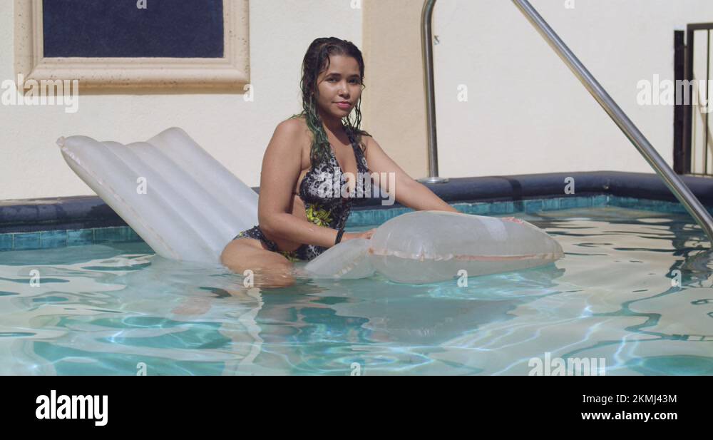 Sexy bikini model floating on an inflatable at a pool Stock Video Footage - Alamy