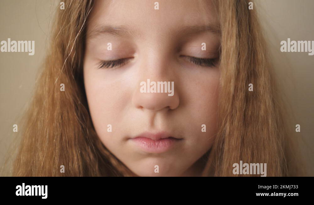 Close up female face of desperate child looking down indoor. Portrait ...