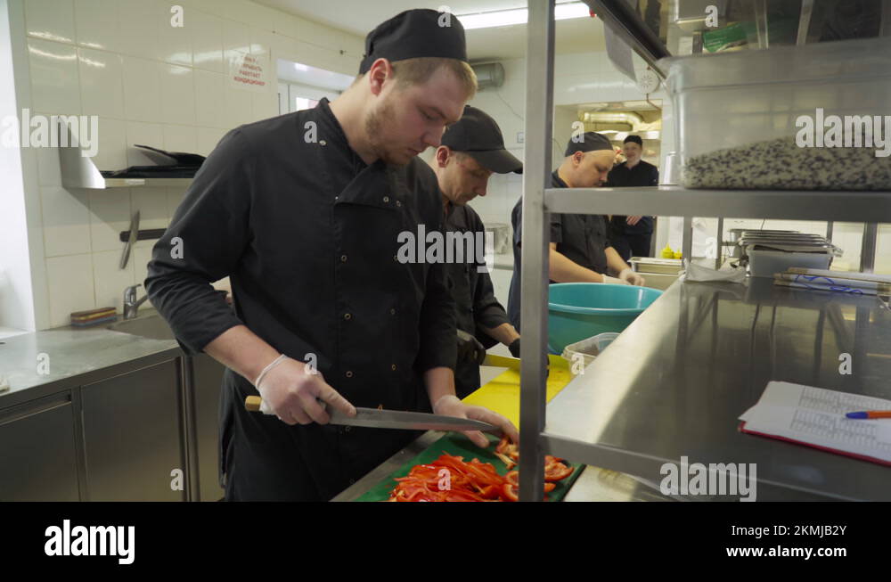 Multiple Cooks are Slicing the red peppers and tomatoes for Fast Food ...