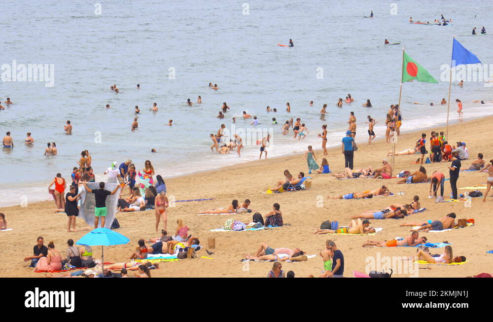People sunbathing on Grande Plage beach and having a swim in the ...