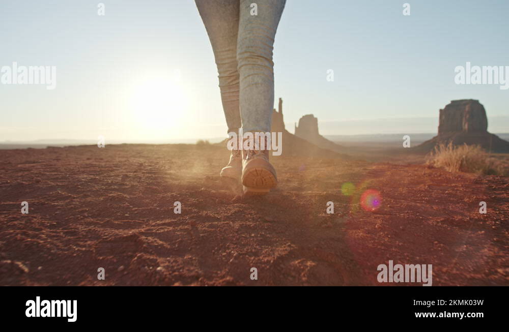 Low view of female feet in boots steps at red desert landscape, woman ...