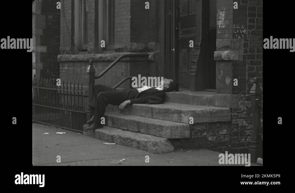 1940s: Man lies on stoop of building, sleeping. Two kids walk by ...