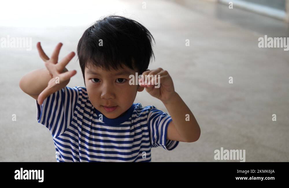 Asian child boy showing hands and fingers gesture like traffic lights ...