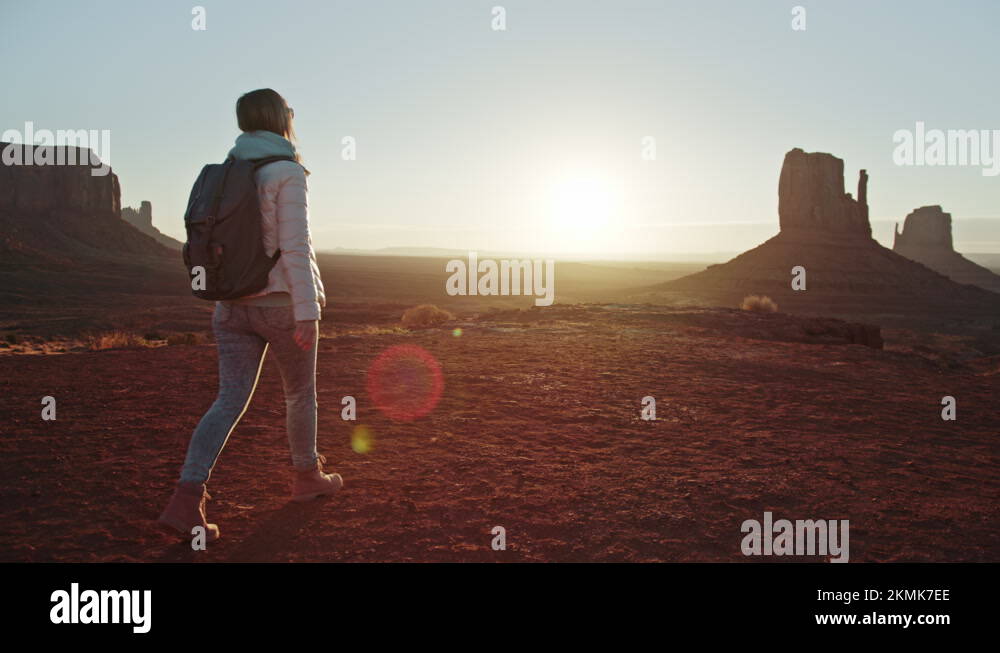 Happy elevated woman in slow motion walking by red desert in Monument ...