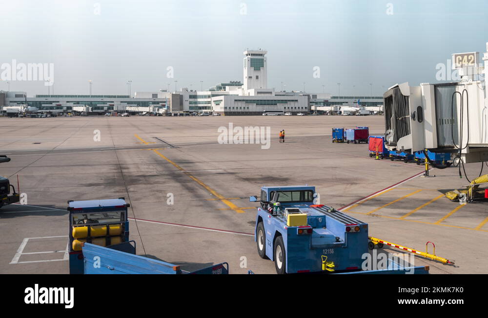 Time-lapse plane pulling into jet bridge at airport with workers and ...