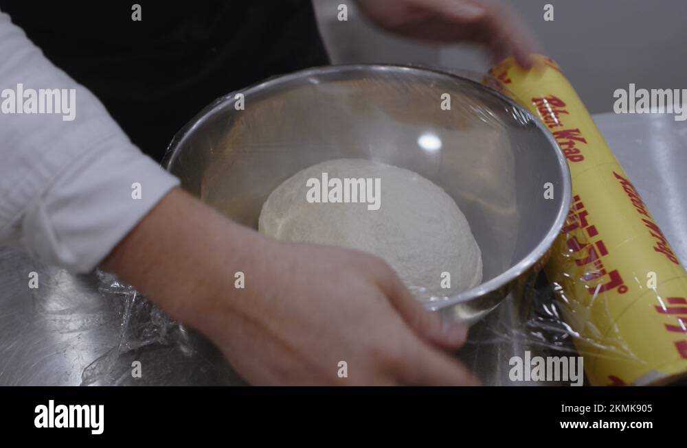 Chef covers the bowl with the pizza dough before the dough rising ...
