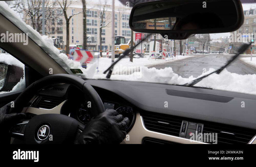 Woman driving car on almost empty street due to snow falling in central ...