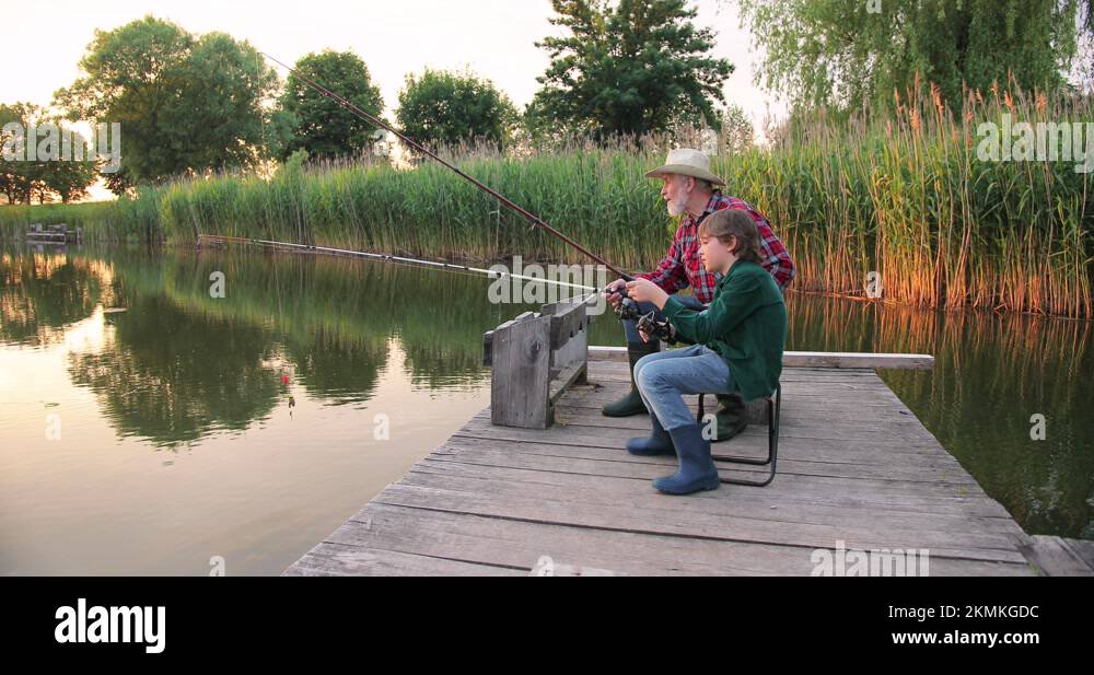 Low angle view of the little teen boy casting a line at the water while ...