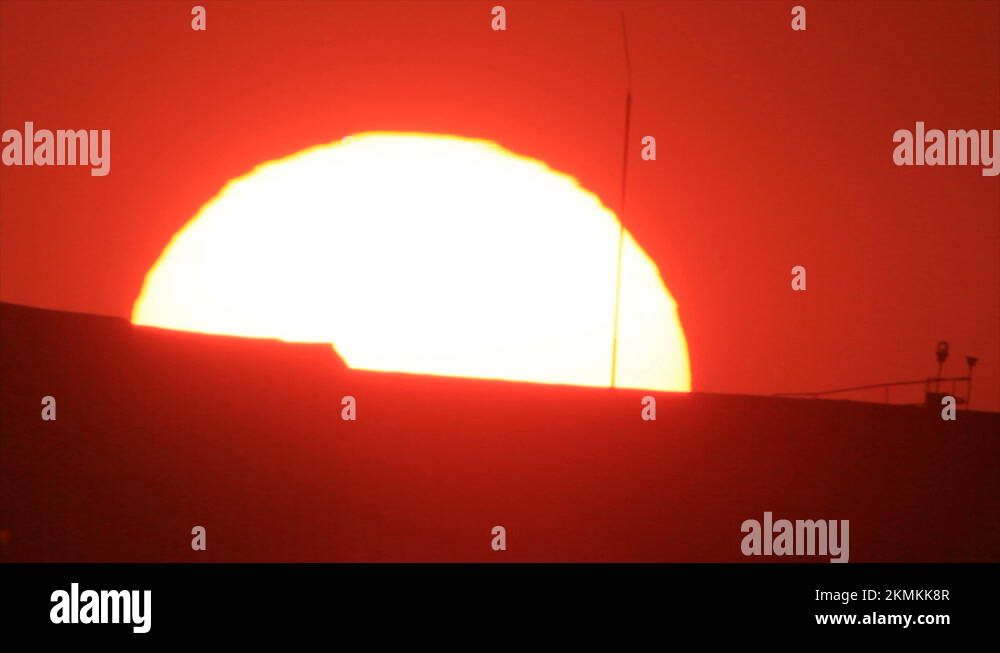 The sun disc disappears behind the roof ridge Stock Video Footage - Alamy