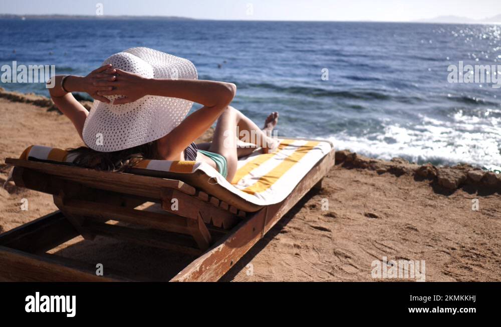 Beautiful woman sunbathing on a beach at tropical travel resort ...