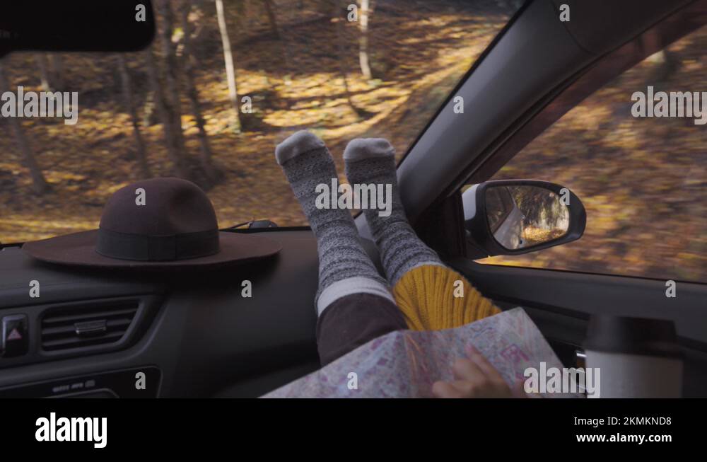 Woman in driving car with legs on dashboard Stock Video Footage - Alamy