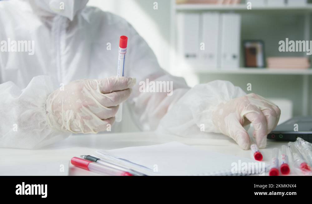 Marking PCR tests in laboratory, doctor writing results on COVID-19 ...