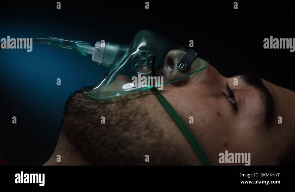 Sick patient lying with oxygen mask in hospital ward, serious bad human ...