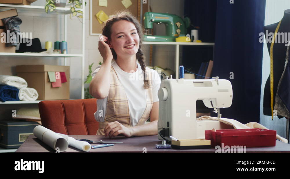 Woman dressmaker smiling portrait, tailoring using modern sewing ...