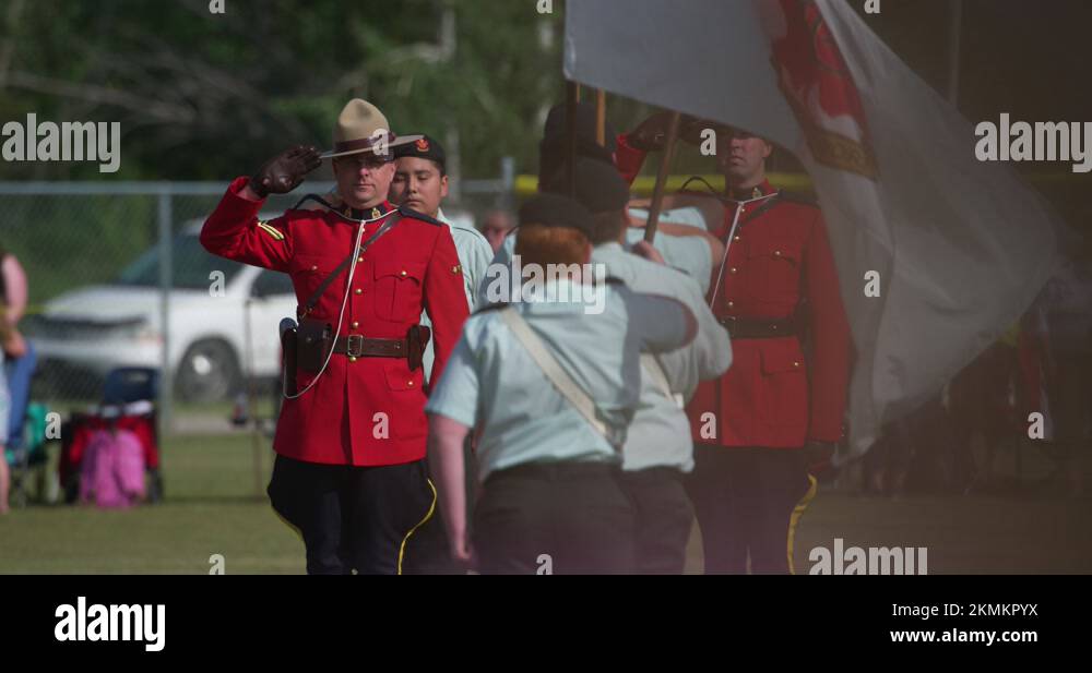 RCMP officer salutes Canadian army cadets holding flags in slow motion ...