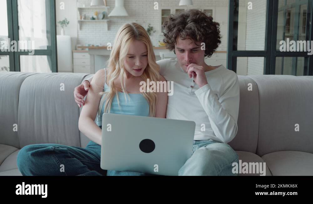 Young Woman Sitting In Couch With Computer On Laps With Smiling Pretty