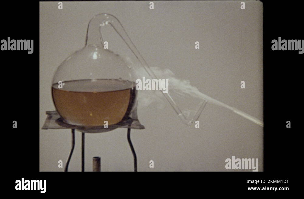 1970s: Smoke being blown at liquid filled flask. Smoke blowing over ...