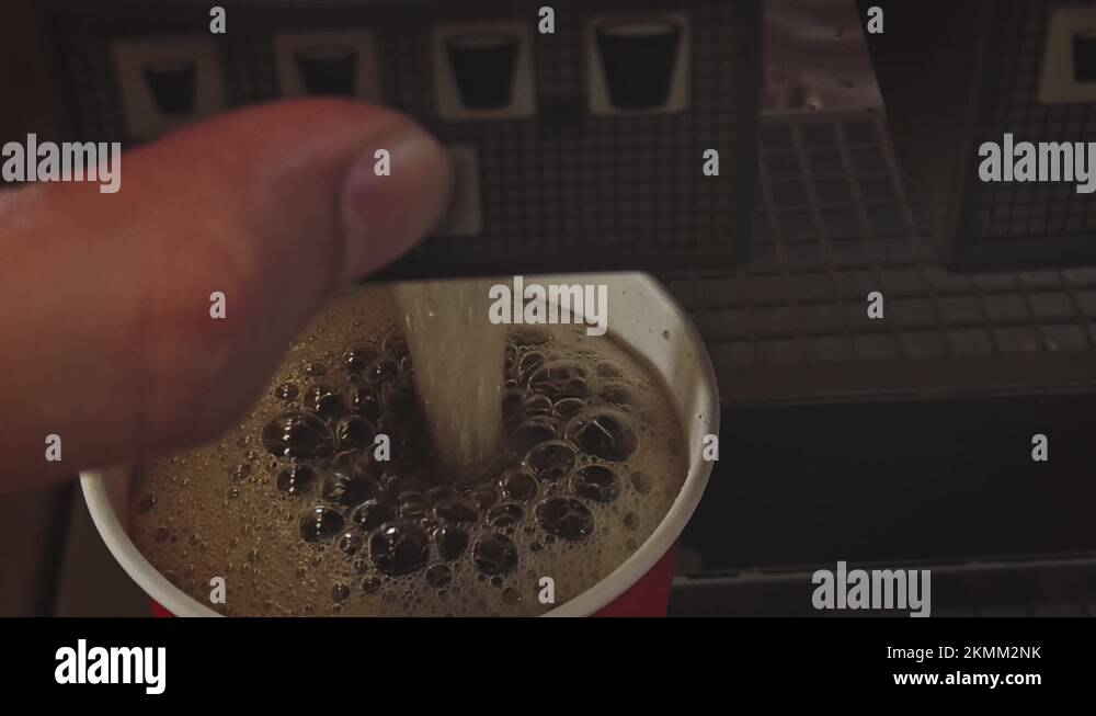 Over Pouring soft drink soda cola into paper cup using machine Stock ...