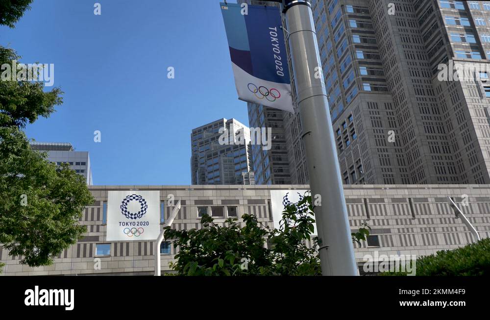 Small Olympic flag sign on street pole with large Tokyo 2020 Olympic ...
