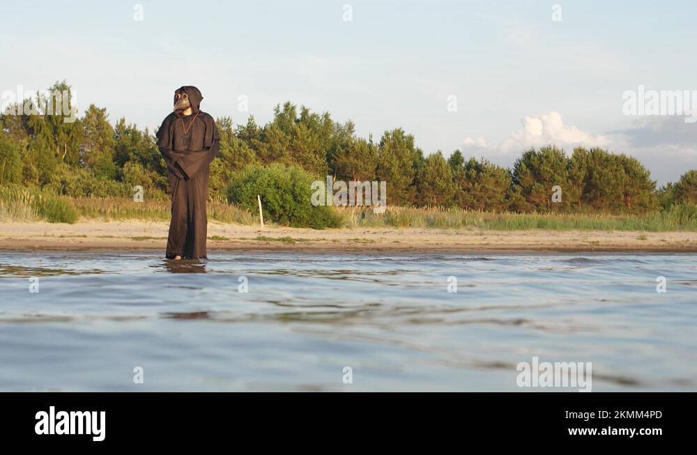 Cinematic blurred environment. The monk in a black suit crossed the sea ...