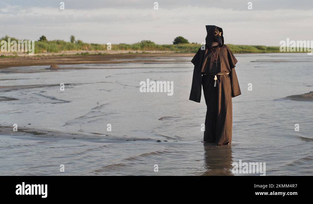 Cinematic blurred environment. The monk in a black suit crossed the sea ...