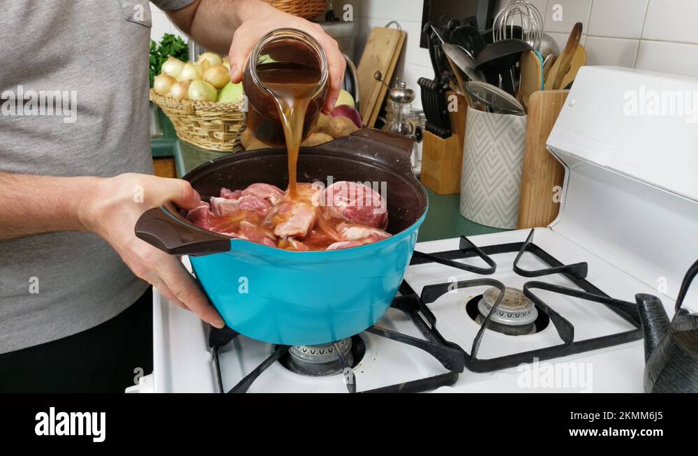 Adding or pouring jar or beef stock into pot of raw cuts of beef Stock ...