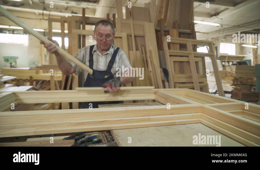 A carpenter is placing the multiple window frame details on the ...