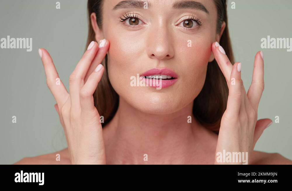Beautiful Young Woman with Clean Fresh Skin standing over light grey ...