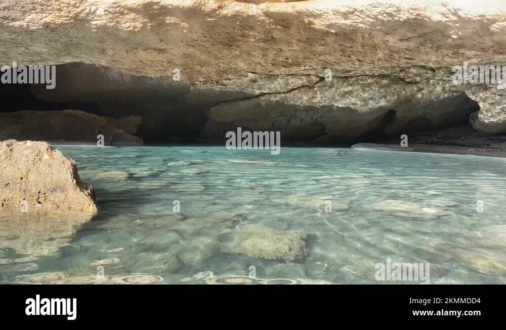 Sea blue lagoon cave grotto in limestone cliff Stock Video Footage - Alamy