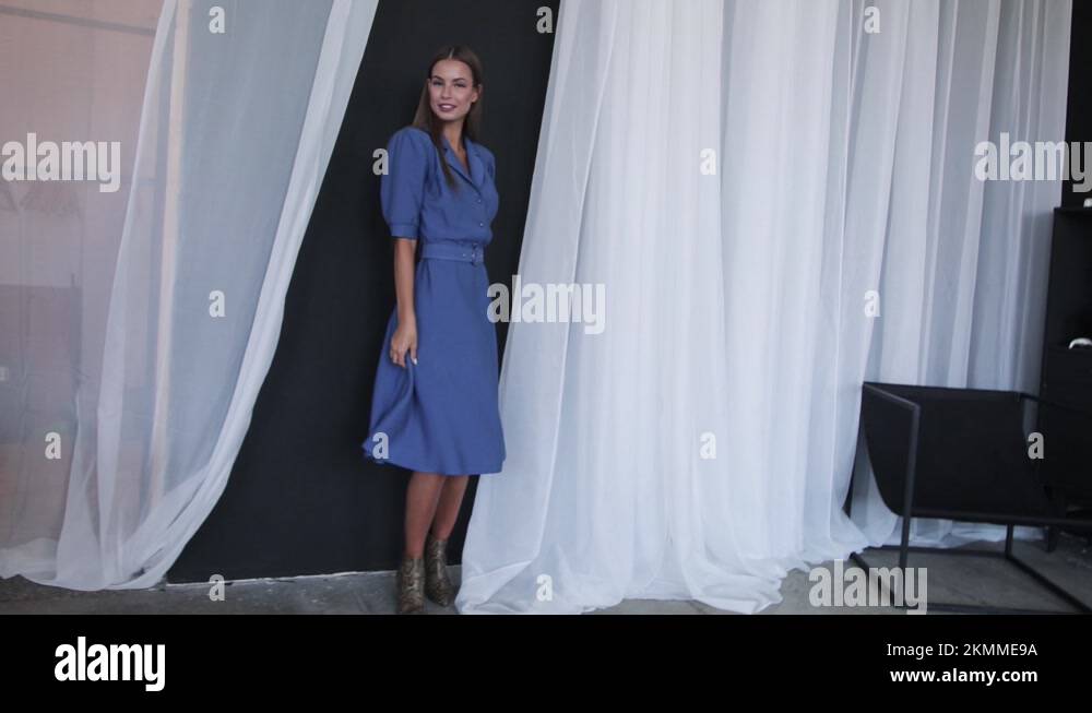 Beautiful girl on the background of a curtain at home.A woman walks and ...