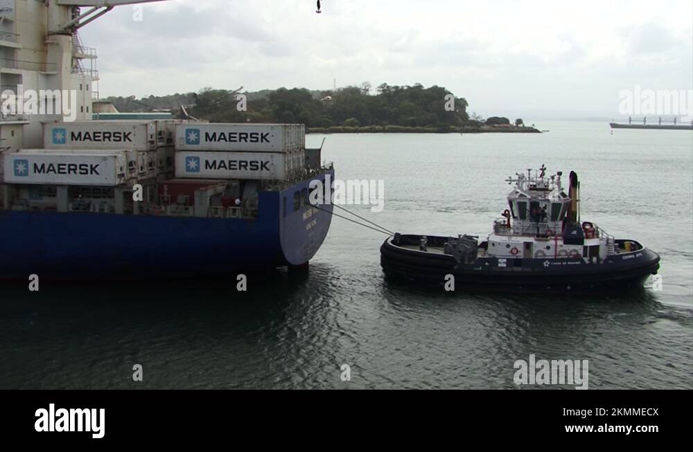 Panama Canal tugboat pulling the container ship in Gatun Lake Stock ...