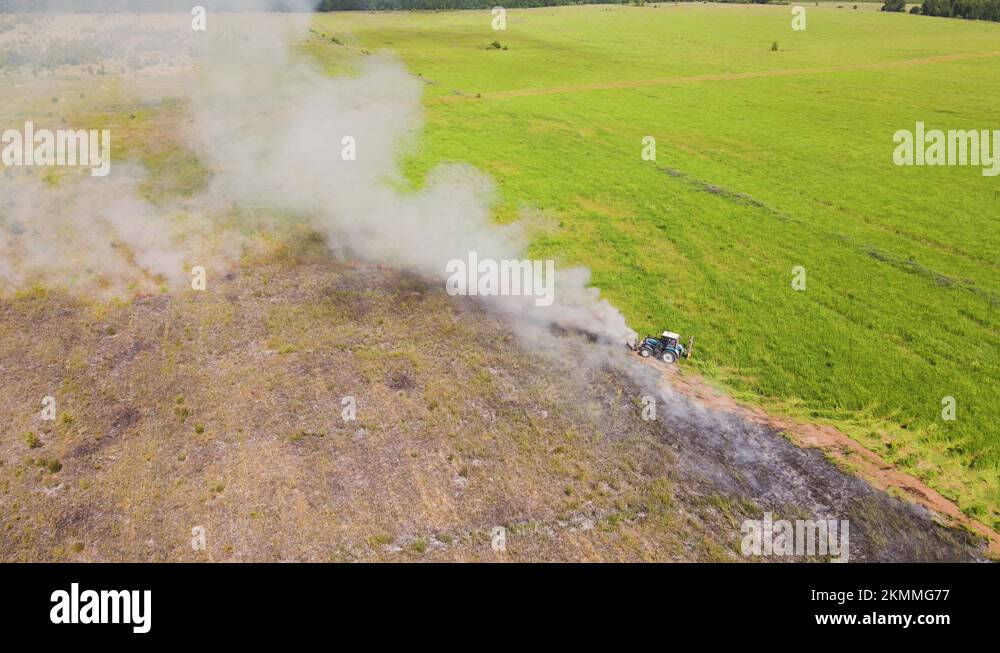 Puffs of smoke in the field, next to the tractor extinguishes the fire ...