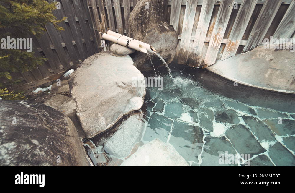 Water Coming Out From Bamboo Pipe Into An Outdoor Onsen (Hot Spring) In ...