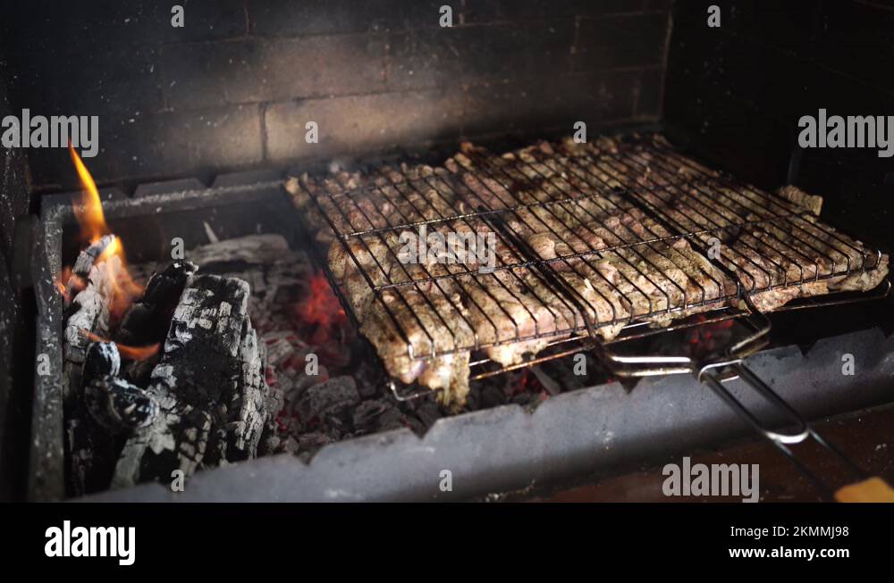 meat is cooked on firewood burning in the barbecue oven. grill in the ...