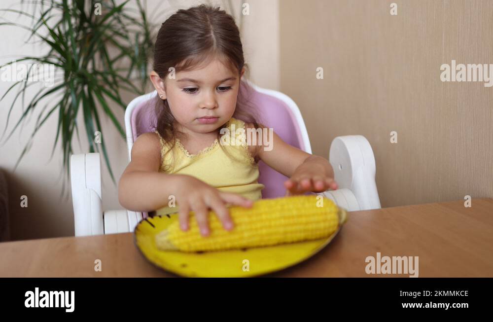 Adorable little girl put hand on corn and ask her mom to eat. Hot ...
