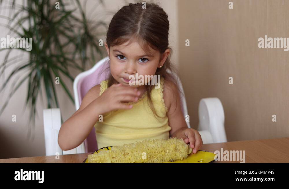 Cute little girl fish eating corn and wipes her mouth. Adorable kid in ...