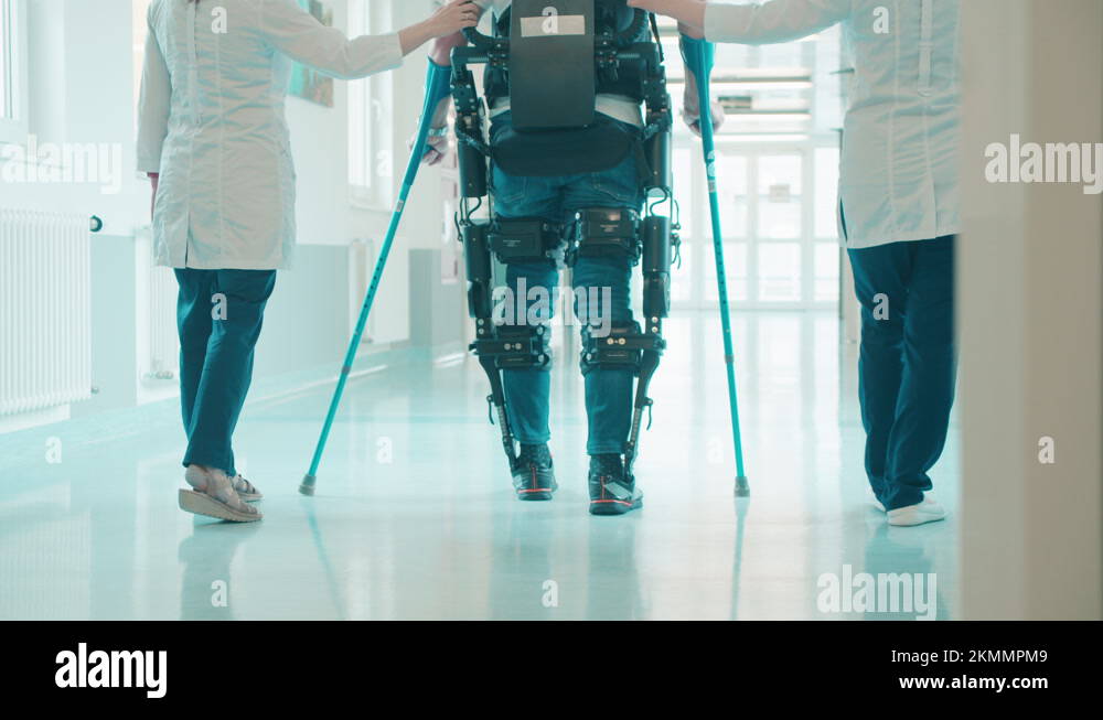 Doctors are helping a man in the exosuit to walk with crutches Stock ...