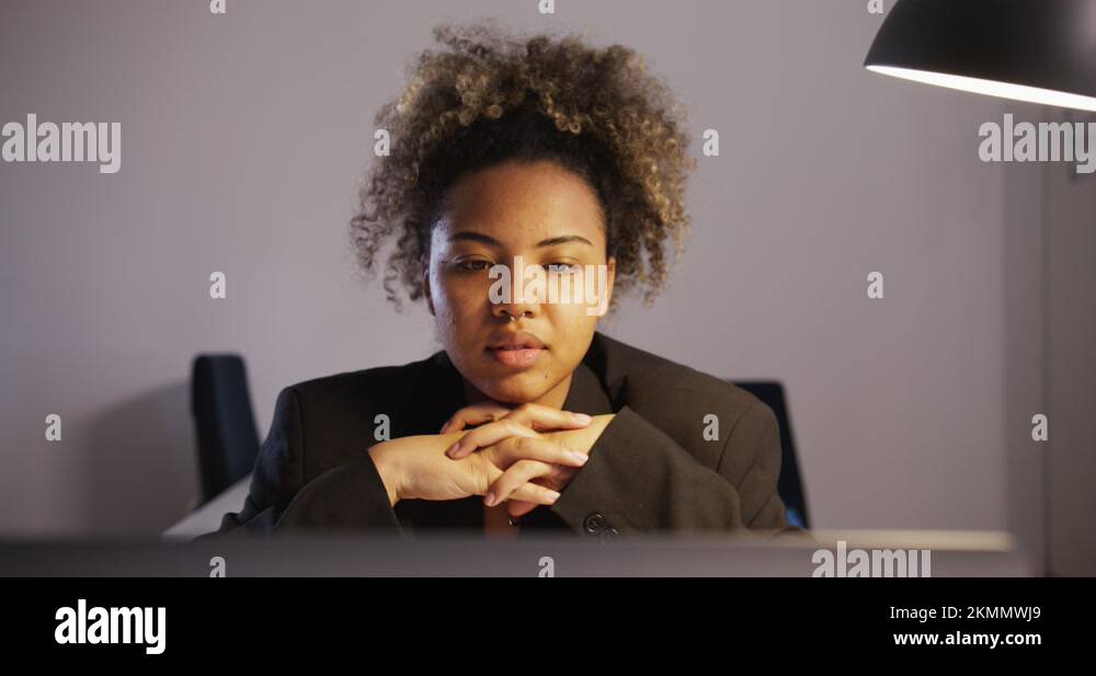 black girl in suit looks at monitor smiling and wiggles her hands in ...