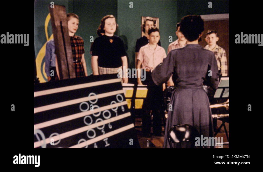 1950s: Classroom. Music teacher conducts as students sing. Teacher ... 1950s: Classroom. Music teacher conducts as students sing. Teacher ...