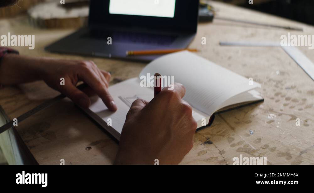 man makes a pencil drawing in a notebook using a ruler close-up Stock ...