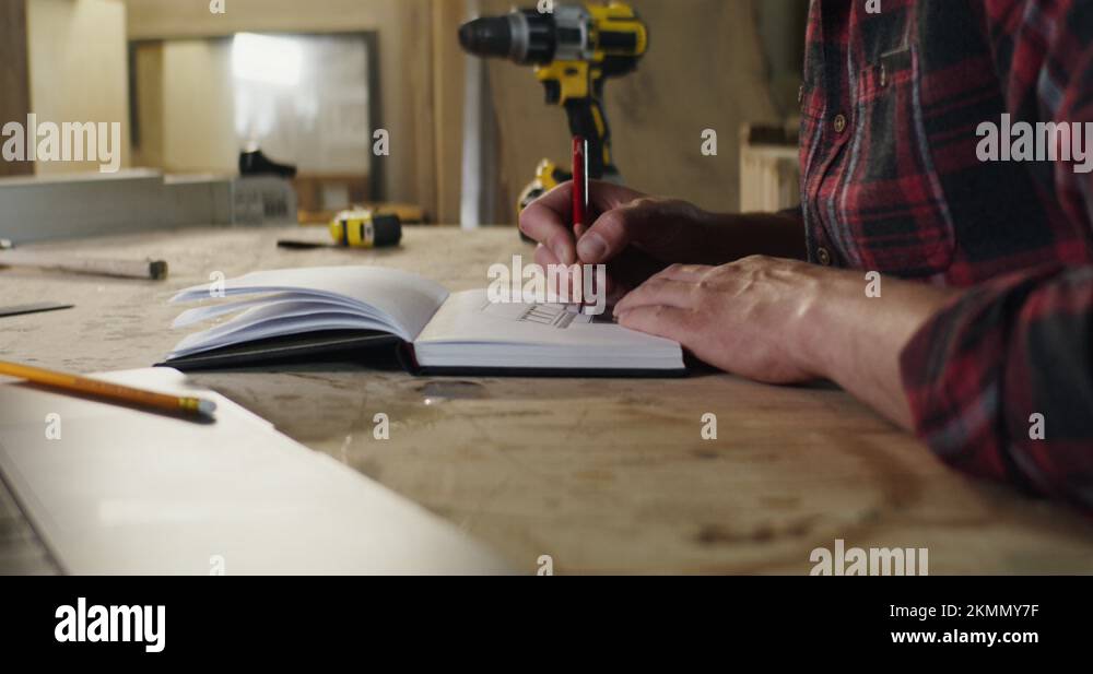 man makes a pencil drawing in a notebook using a ruler close-up Stock ...