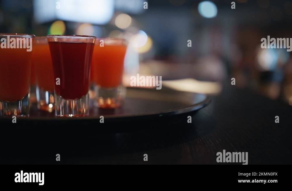 Pan up: Red or orange shots at bar counter in pub with blue blinking ...