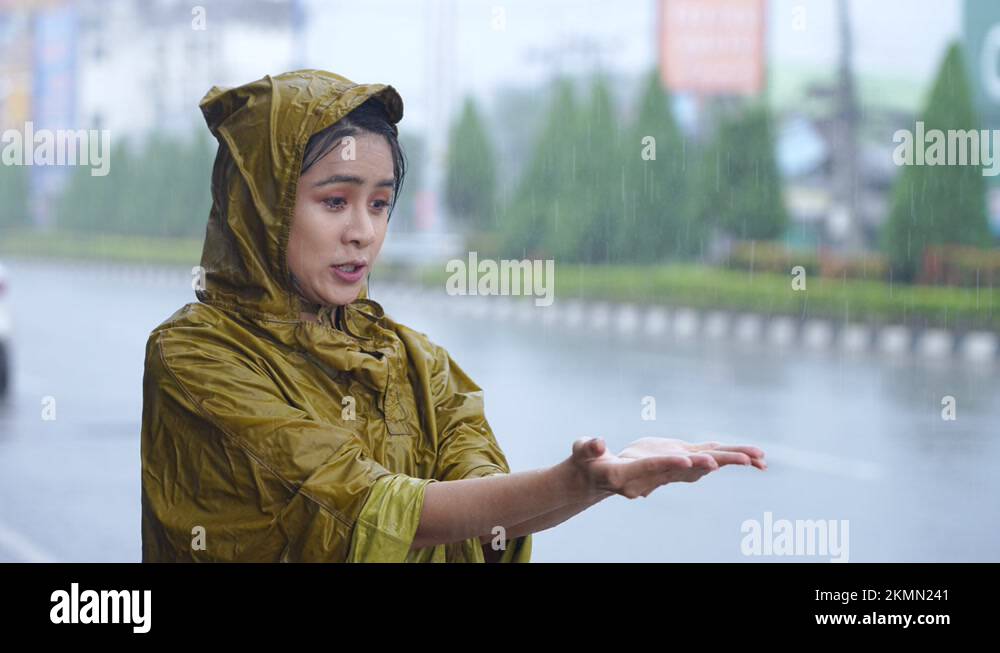 Female office worker raincoat stuck in a rain, hands collecting ...