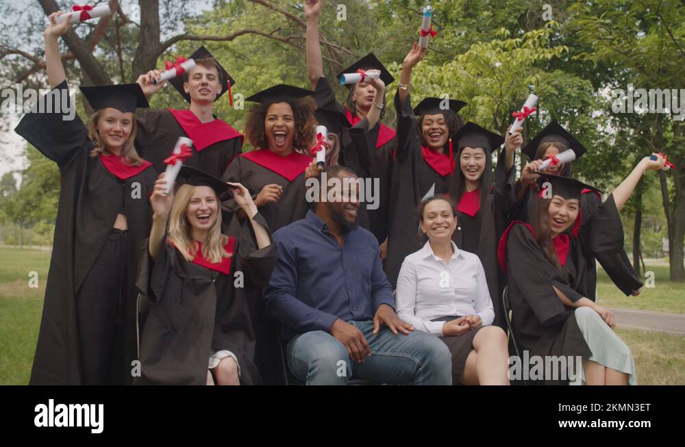 Excited multiethnic graduates with diplomas and academic staff ...