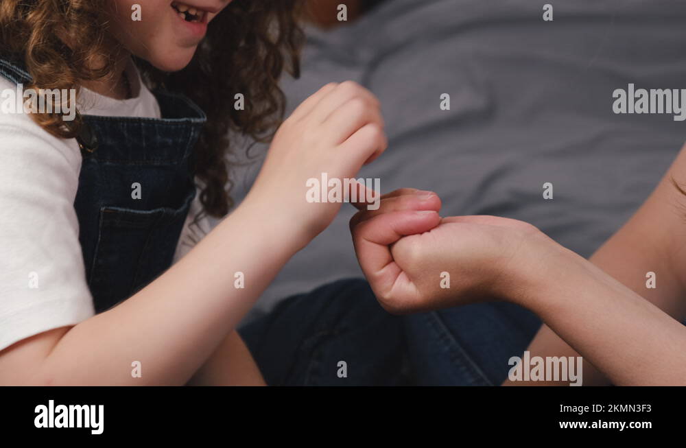 Daughter child with mother playing game counts fingers shows hands ...