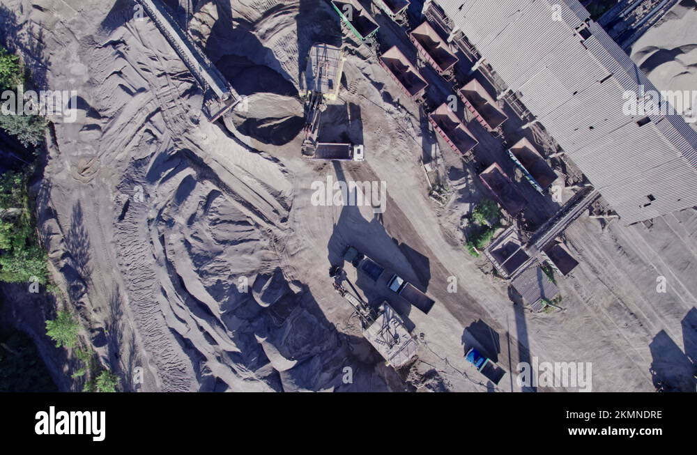 Excavators and tractors load crushed stone and rock into dump trucks ...